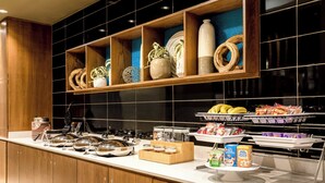 Uma mesa de buffet com diversos alimentos e acompanhamentos.