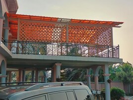 Varanda com estrutura treliçada e um carro estacionado abaixo.