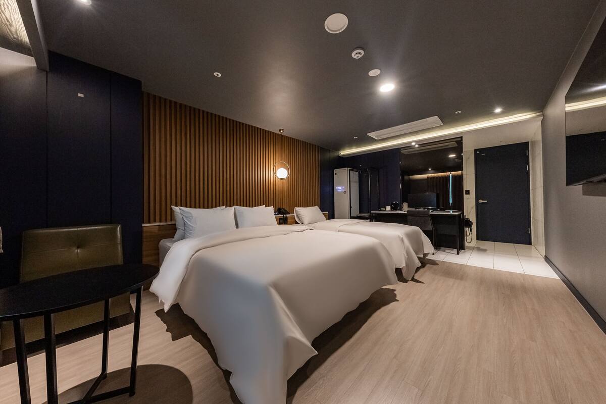 Quarto de hotel moderno com uma cama grande, uma escrivaninha e um espaço de estar.