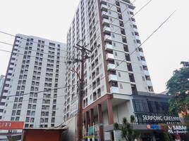 Um edifício alto com várias varandas e um andar térreo comercial.