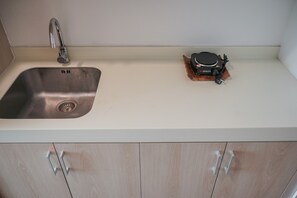 Quarto | Kitchenette privada | Um frigorífico, uma placa de cozinha, utensílios de cozinha