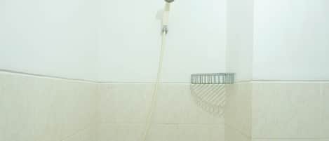 Um chuveiro com um chuveiro manual e uma torneira fixada na parede.