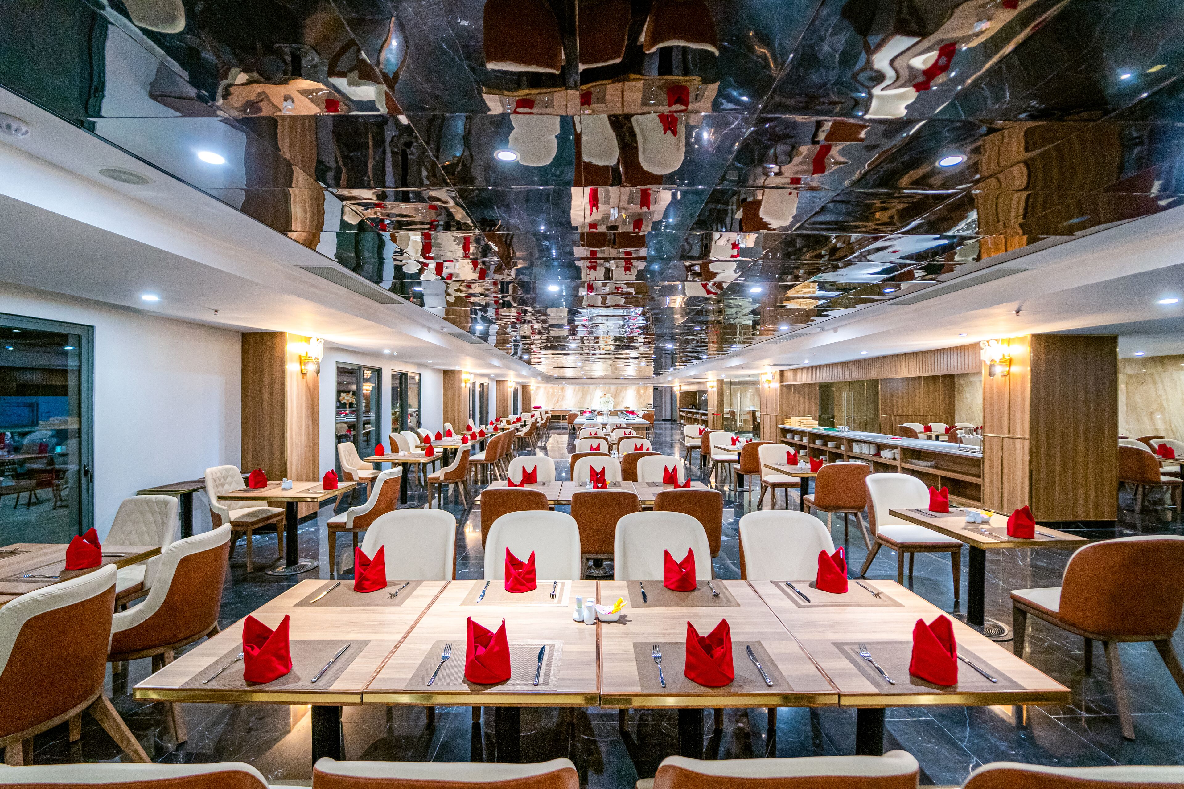 Um restaurante amplo com várias mesas e cadeiras, dispostas em linha.