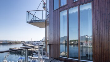 Um edifício moderno com grandes janelas com vista para um porto de recreio.