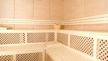 Uma sauna de madeira com design treliçado, bancos e um balde de madeira com concha.