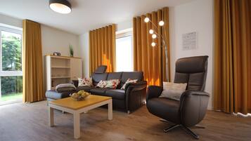 Refugium 6 | Sala de estar | Televisor de ecrã plano de 50 polegadas com canais por cabo, televisor