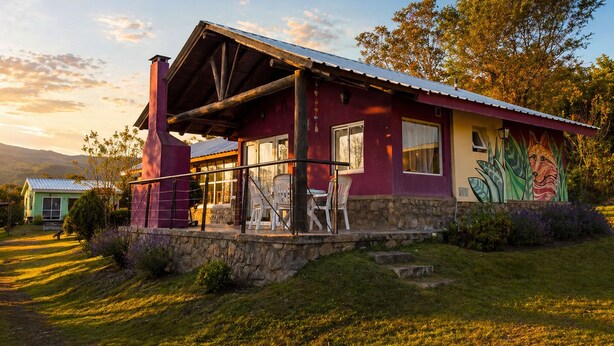 Uma casa com varanda, degraus de pedra e um mural.