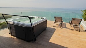 Uma banheira de hidromassagem em uma varanda com vista para o mar.