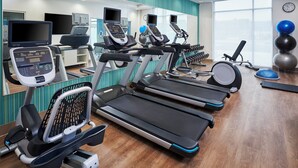 Academia com esteiras, elípticos e bolas de exercício.