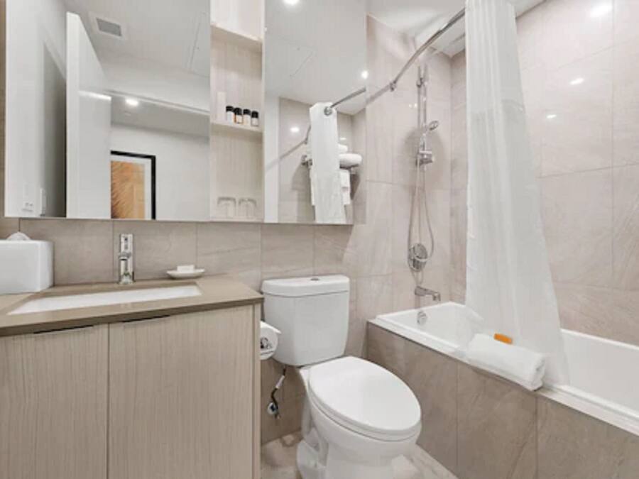 Uma casa de banho moderna com sanita, lavatório e chuveiro.