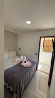 Quarto de hotel com cama, janela e porta.