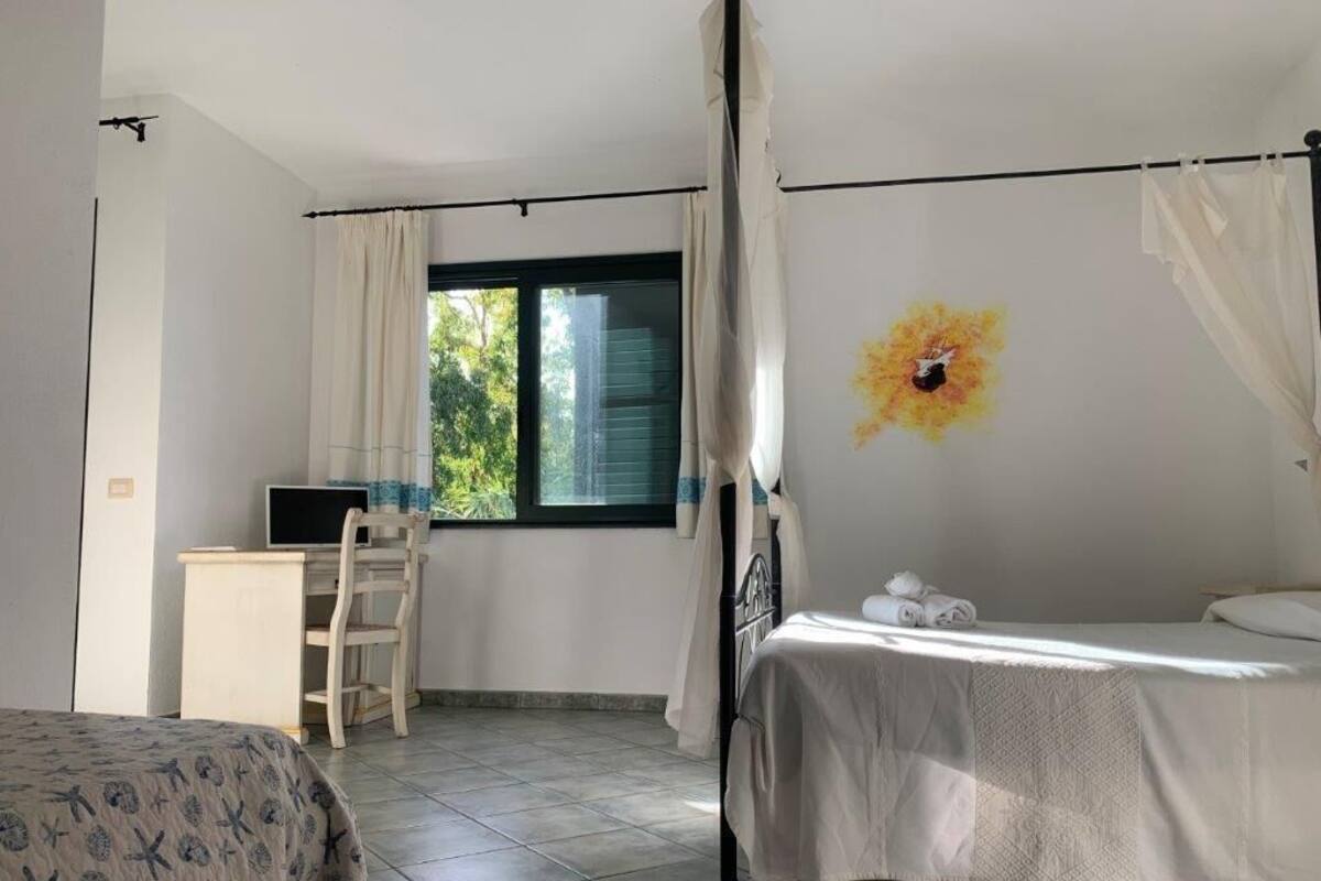 Quarto com uma cama, uma escrivaninha e uma cadeira.