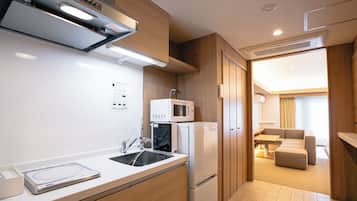 Um frigorífico/congelador grande, um micro-ondas, uma placa de cozinha