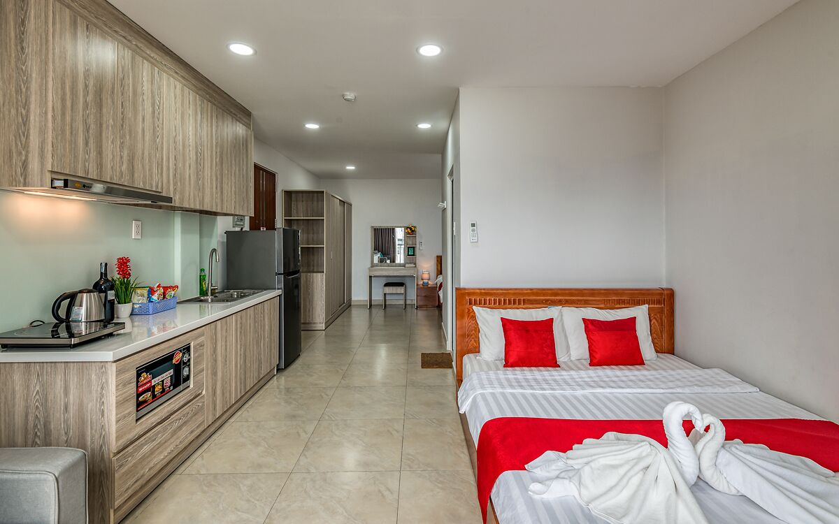 Quarto de hotel com cama, cozinha e banheiro.