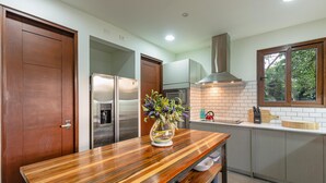 Uma cozinha moderna com armários de madeira, eletrodomésticos de aço inoxidável e bancada de madeira.