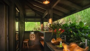 Uma casa de banho moderna com um banco de madeira, uma pia com cuba de madeira e um espelho grande.