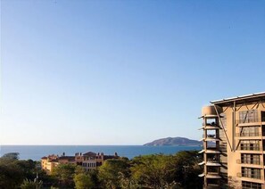 Um edifício costeiro com várias varandas com vista para o mar.