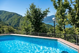 Piscina com vista para montanhas e um lago.