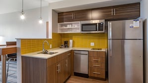 Uma cozinha compacta com lava-louças, micro-ondas e frigorífico.