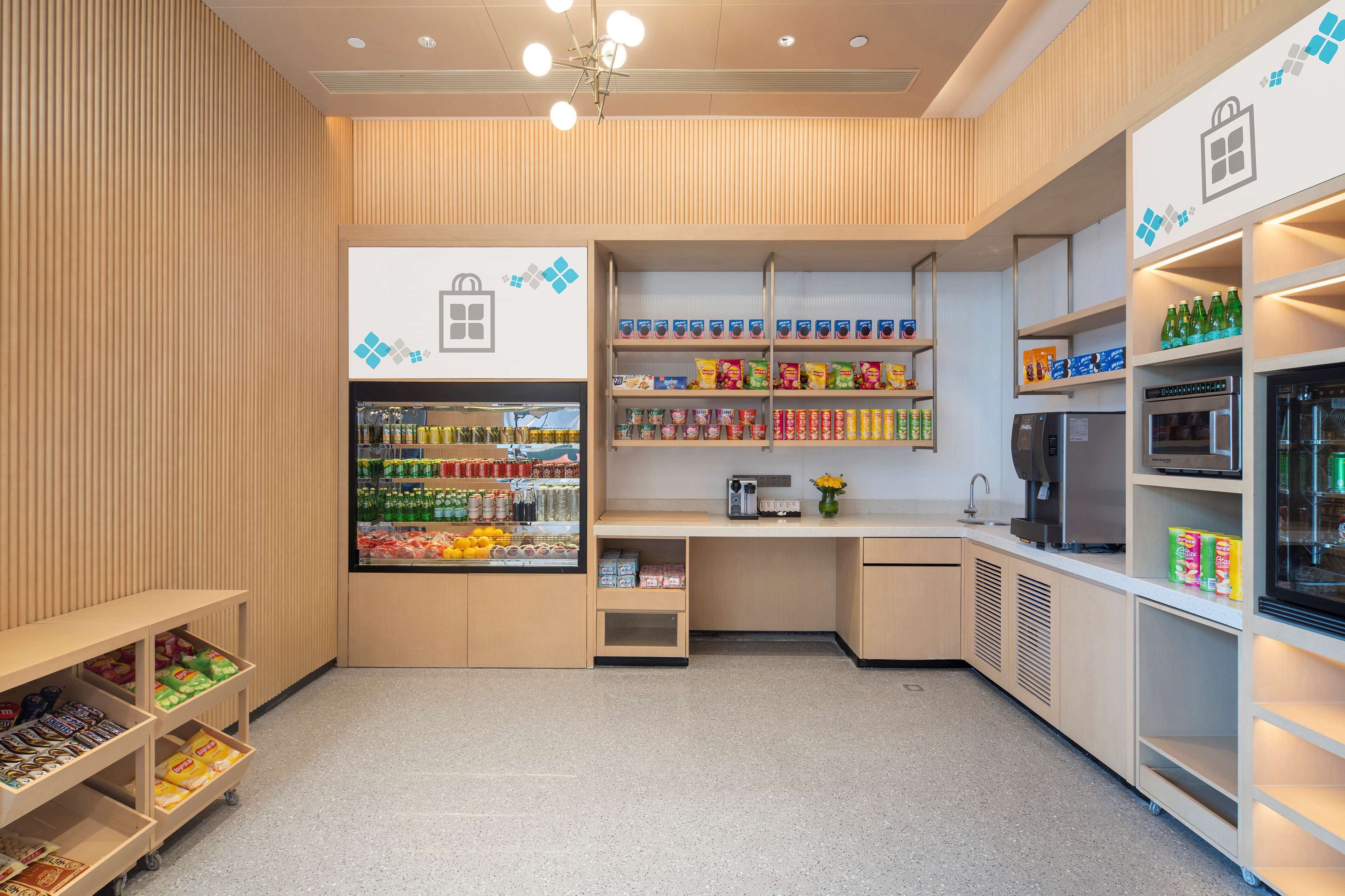 Uma loja moderna e bem iluminada, com diversos produtos embalados nas prateleiras e uma seção refrigerada.