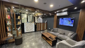 Uma sala de estar moderna com um sofá, mesa de centro e televisão na parede.