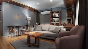 Uma sala de estar moderna com sofá, poltrona, mesa de centro, luminária de chão e estante.