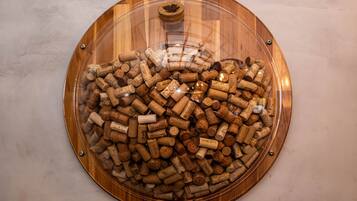 Um expositor circular de madeira com tampa de vidro, contendo diversas rolhas de vinho.