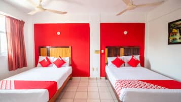 Quarto de hotel com duas camas, paredes vermelhas, roupa de cama branca e ventiladores de teto.