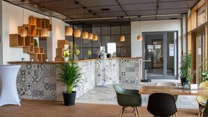 Uma área de recepção moderna com parede estampada, prateleiras de madeira e luminárias pendentes.