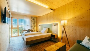 Quarto moderno com cama, mesas de cabeceira, escrivaninha e abajur.