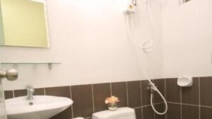 Casa de banho com lavatório, sanita e chuveiro.