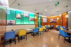 Restaurante com cabines e mesas, piso de madeira e iluminação pendente.