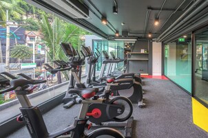 Uma academia com bicicletas ergométricas, esteiras e equipamentos de ginástica.