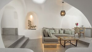 Um interior moderno com teto curvo, sofá modular, mesa de centro e área de jantar com cadeira e mesa.