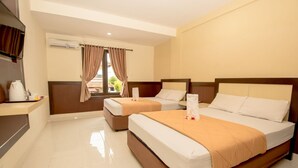 Quarto de hotel com duas camas, minibar, janela com cortinas e ar condicionado.