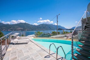 Piscina com vista para montanhas e um lago.