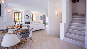 Um interior moderno com área de refeições, um sofá e uma escada.