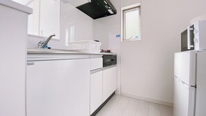 Cozinha moderna com armários brancos, exaustor preto, micro-ondas e forno embutido.