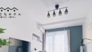 Quarto moderno com cama, mesa de cabeceira e televisão.