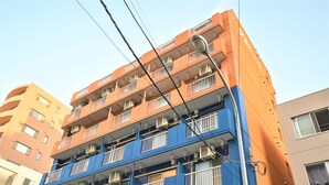 Um edifício com várias andares, varandas e aparelhos de ar condicionado.
