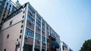 Um hotel de vários andares com fachada moderna, grandes janelas e toldo verde.