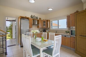 Um micro-ondas, um forno, uma placa de cozinha, mesas de jantar 