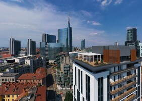 Horizonte urbano moderno com edifícios altos, incluindo um arranha-céu marcante com um pináculo.