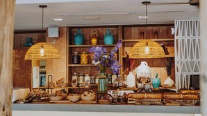 Uma cozinha com luminárias trançadas suspensas, armários de madeira e diversos utensílios de cozinha.