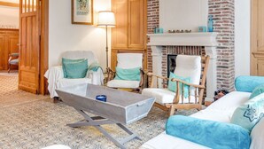 Uma sala de estar aconchegante com lareira, móveis de madeira e ladrilhos estampados.