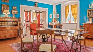 Uma sala de jantar com mesa de madeira, cadeiras e um tapete vermelho estampado.