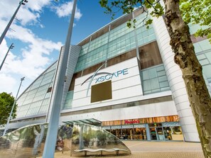 Um edifício moderno com fachada de vidro e uma placa com a inscrição 'XSCAPE'.