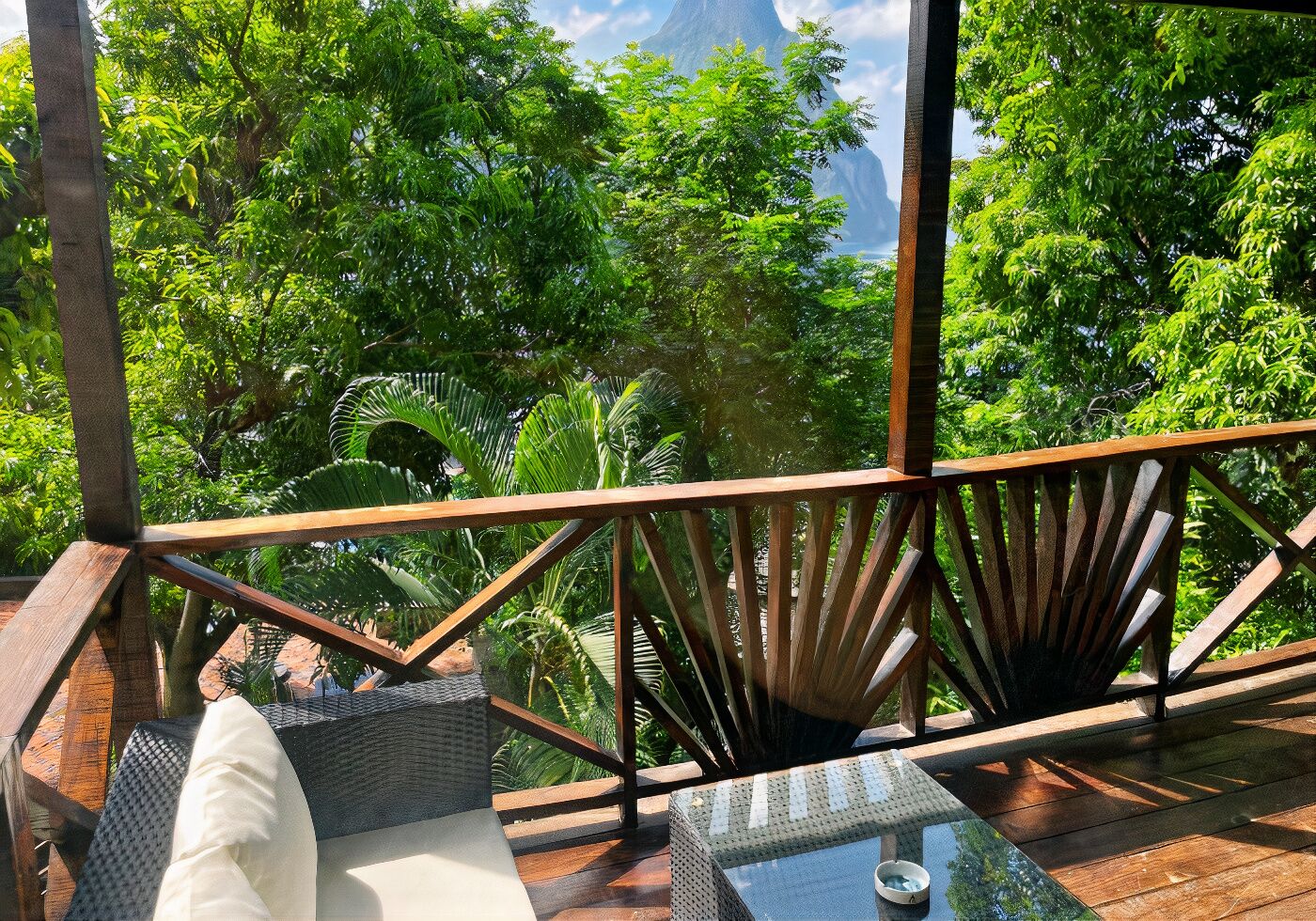 Um deck de madeira com guarda-corpo de vidro, com vista para vegetação exuberante.