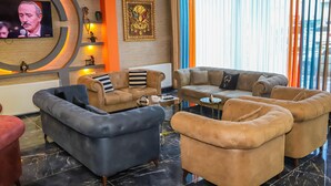 Uma sala de estar moderna com televisão, sofás confortáveis, lareira e uma grande janela com cortinas.