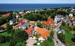 Vista aérea de uma área residencial com casas, uma estrada e um corpo de água ao fundo.